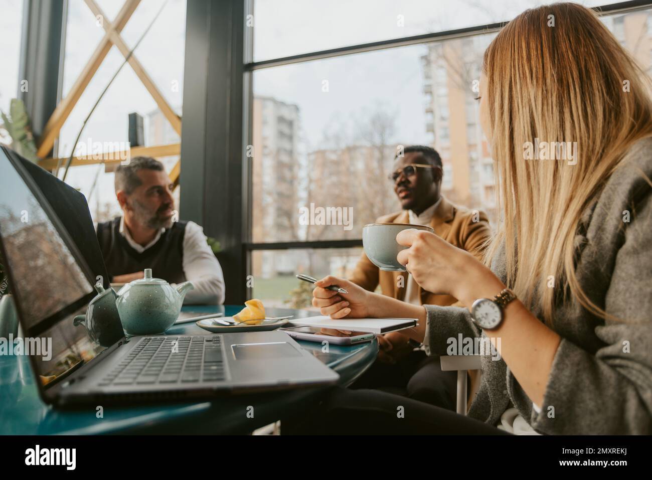Close up of blonde business woman holding her blue tea cup while ...