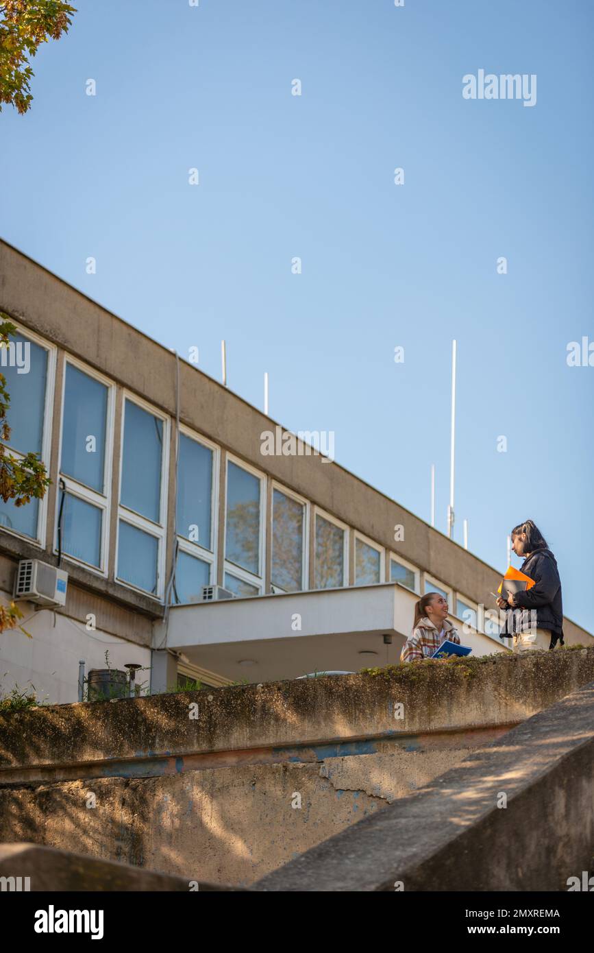 Two beautiful students talking in the school's yard Stock Photo - Alamy