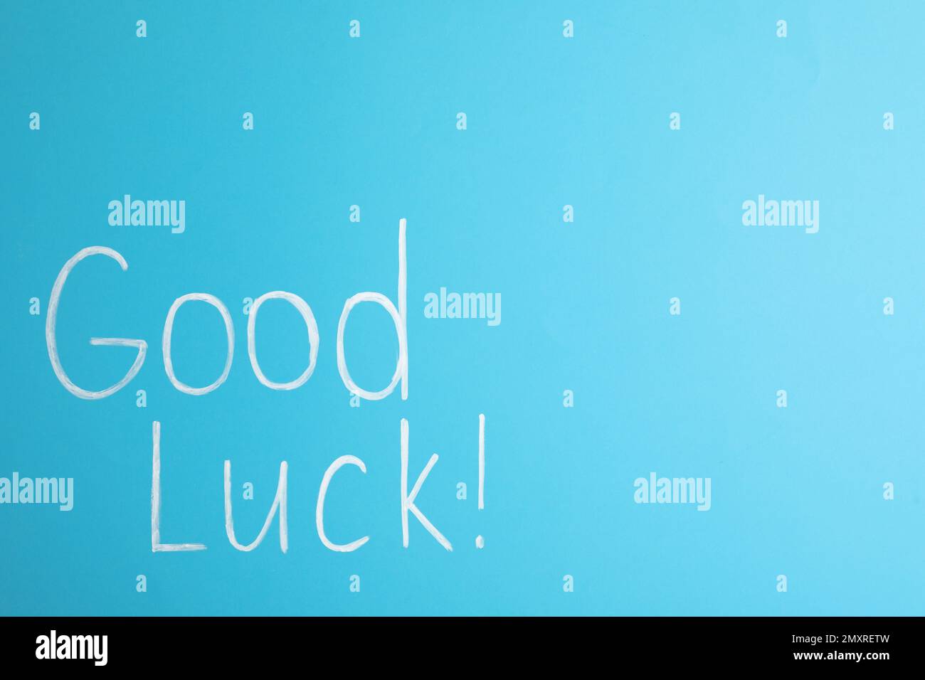 Phrase GOOD LUCK on light blue background, top view. Space for text ...