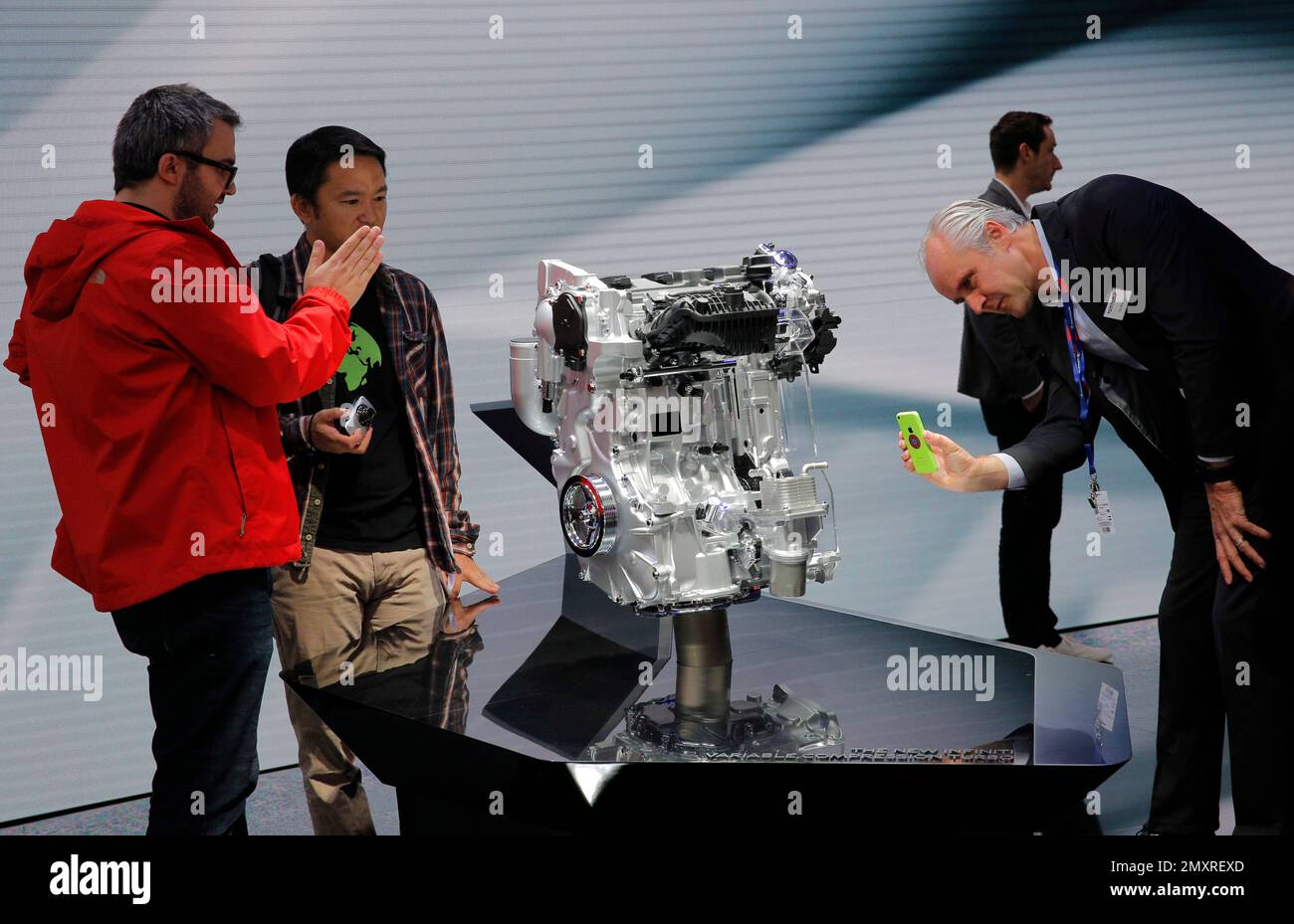 Members of media watch the engine of the Infiniti car with a variable ...