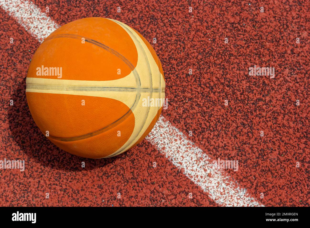Orange ball for basketball lying on the sport court.Sport red court ...