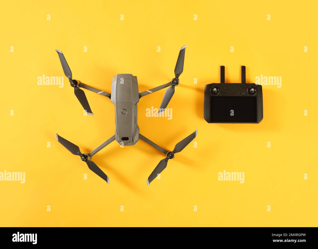 Modern drone with controller on yellow background, flat lay Stock Photo ...