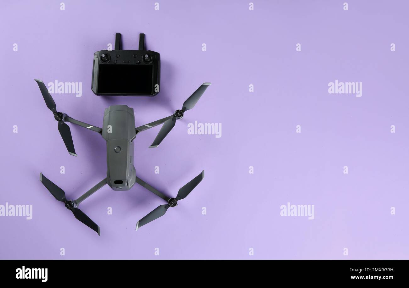 Modern drone with controller on lilac background, flat lay. Space for ...