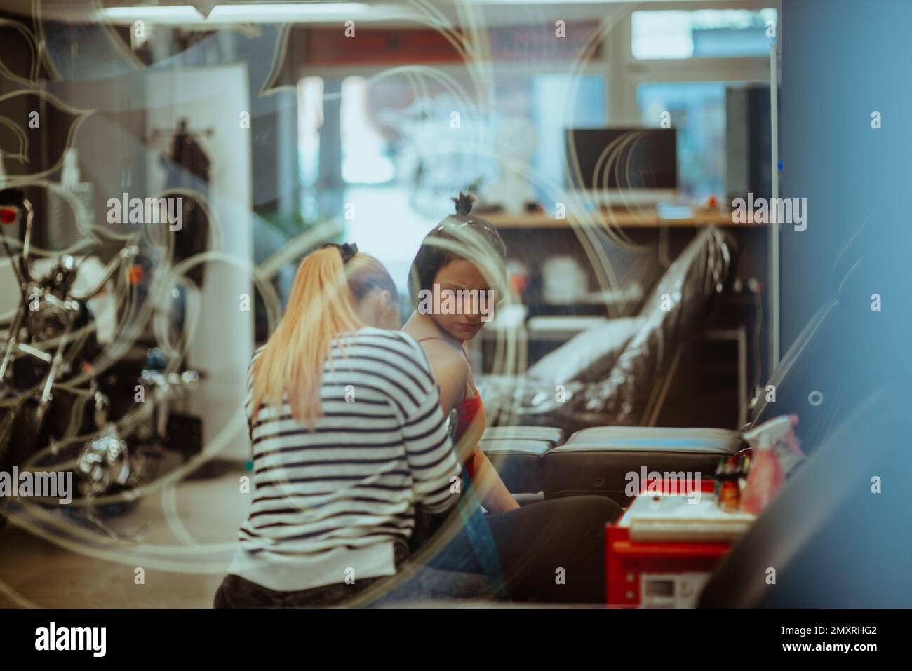 Client is making bad faces while getting tattooed at the studio Stock ...