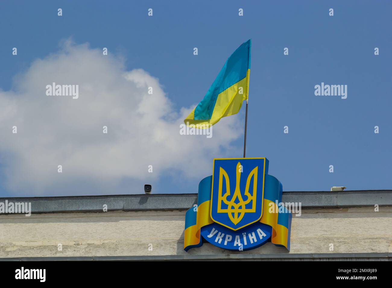 State symbols, flag and coat of arms of Ukraine on sky background ...