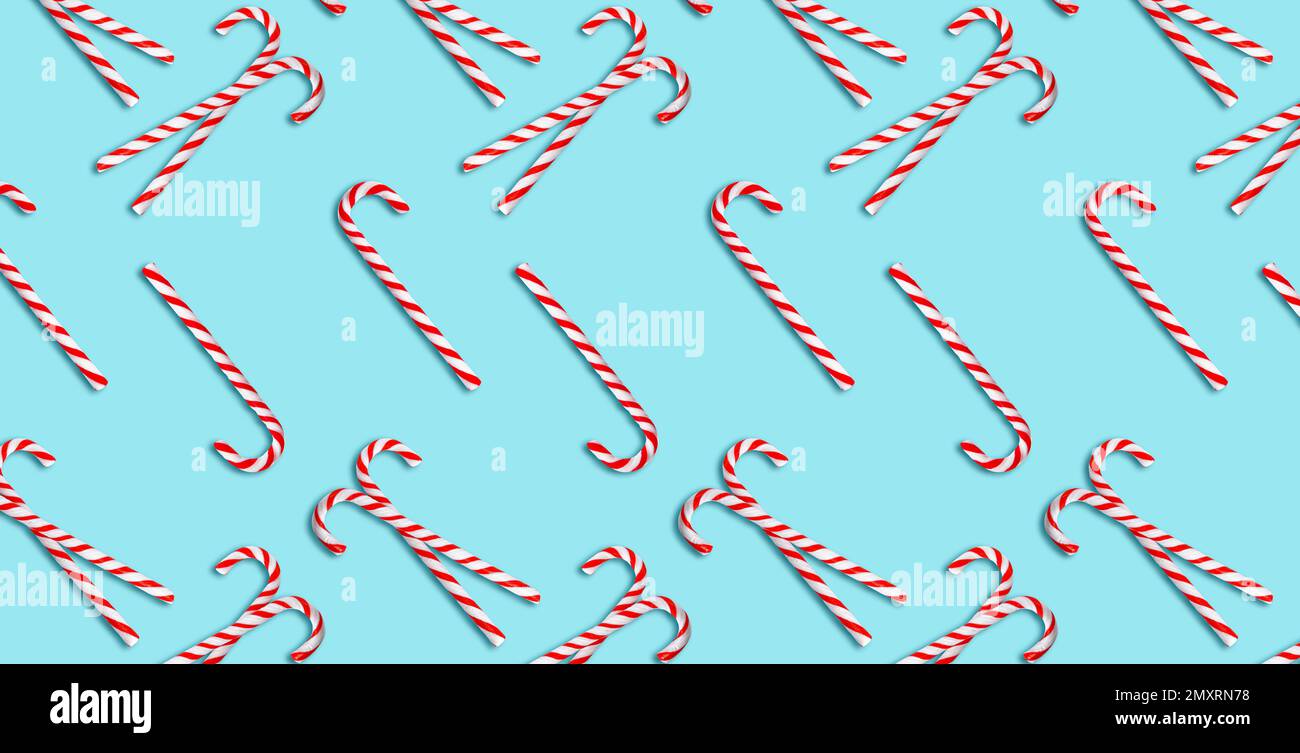 Pattern of Christmas candy canes on pale light blue background, top ...