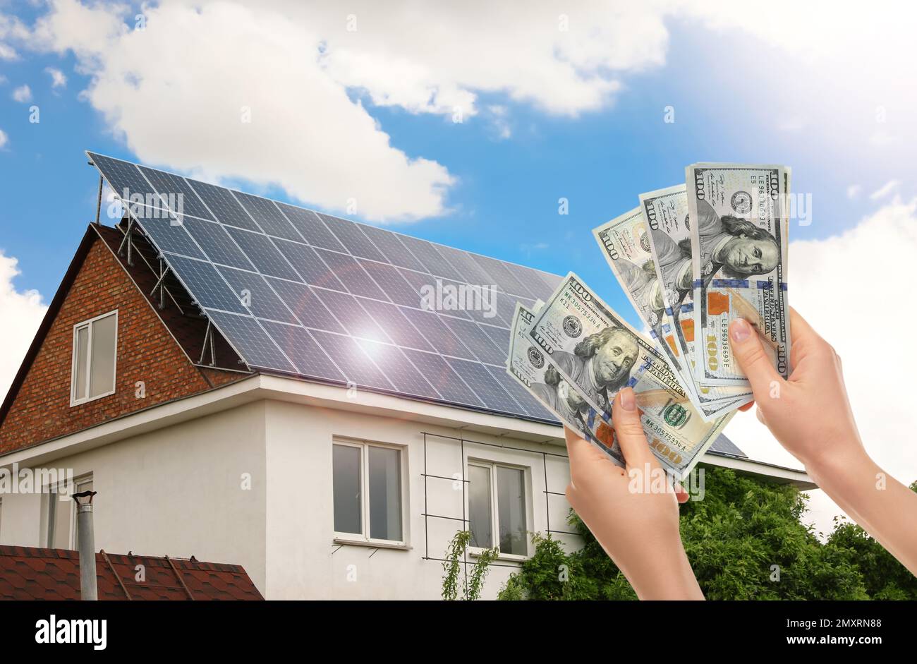 Man counting money against house with installed solar panels. Renewable ...