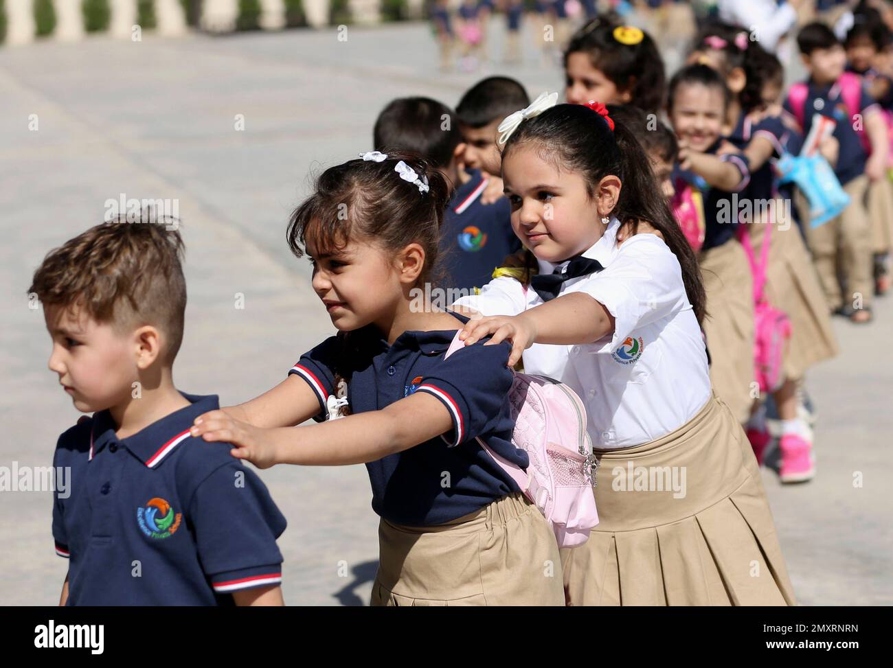 Students line up to enter a classroom in their new uniforms n the first ...