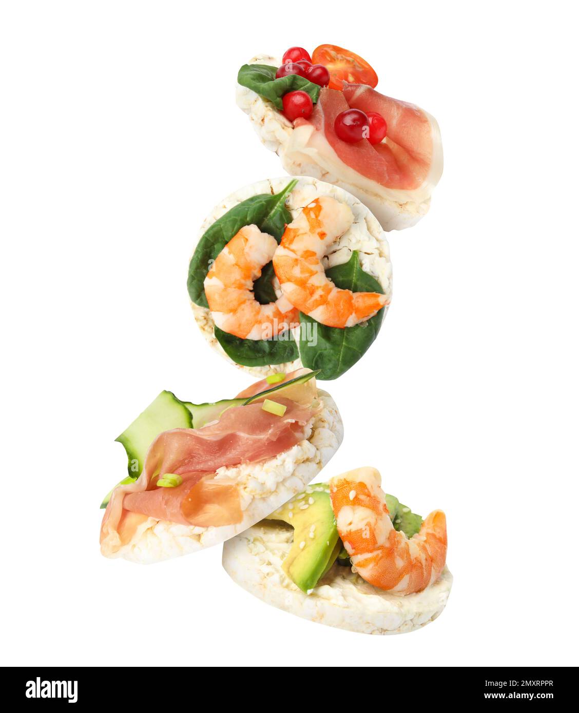 Puffed corn cakes with different toppings falling on white background ...