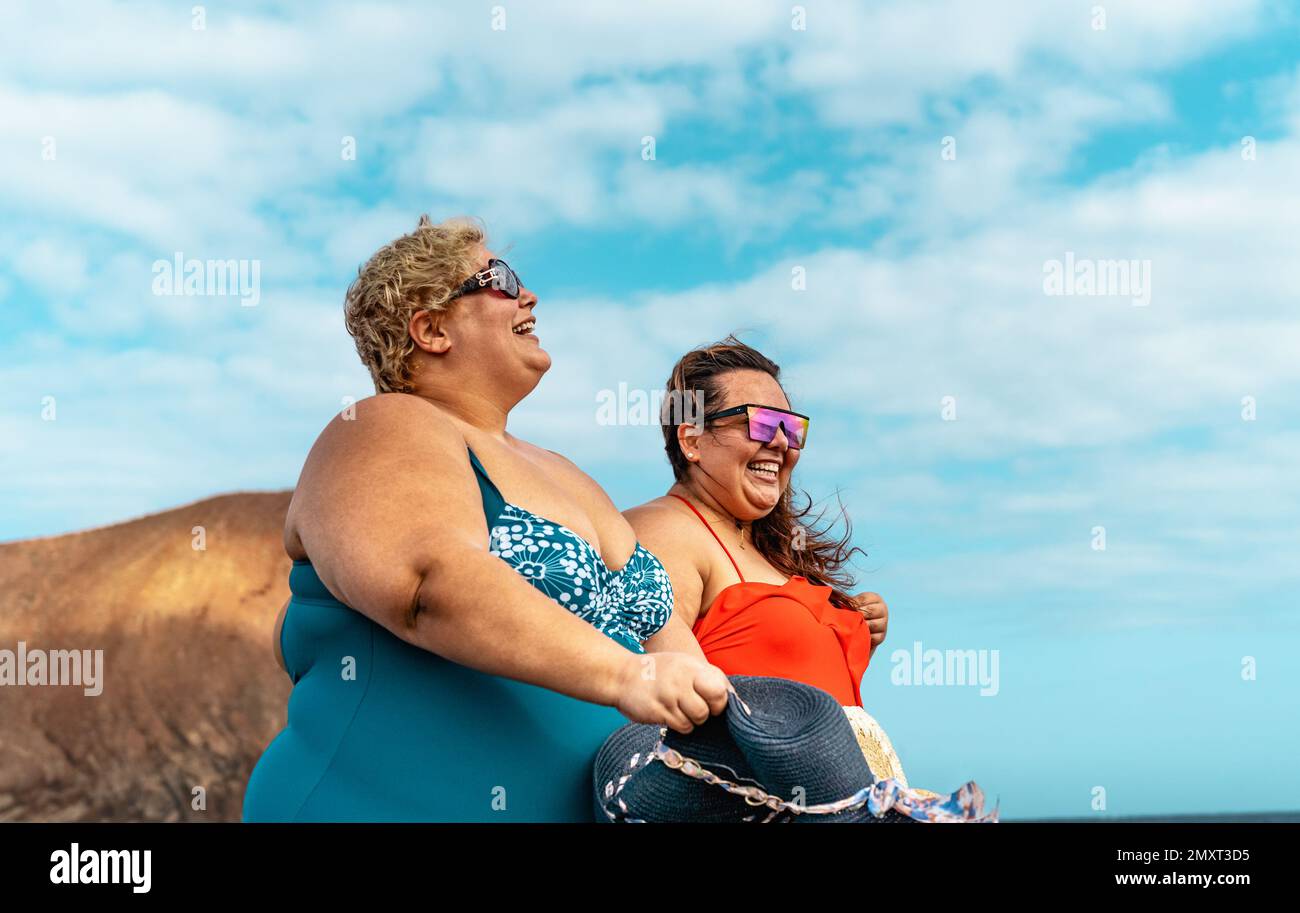 Happy Plus Size Women Having Fun Walking On The Beach During Summer
