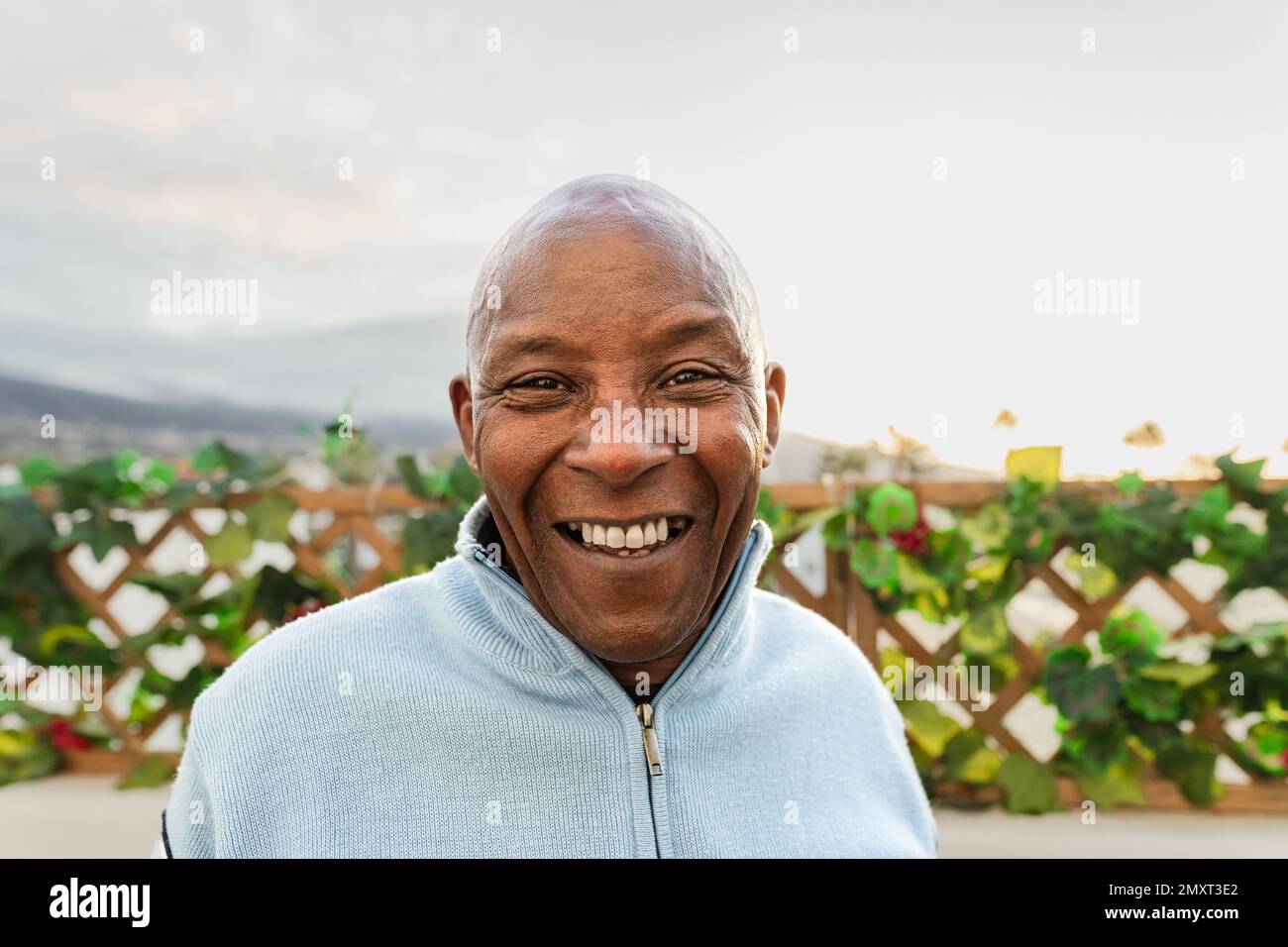 Happy senior African man smiling in front of camera on house patio ...