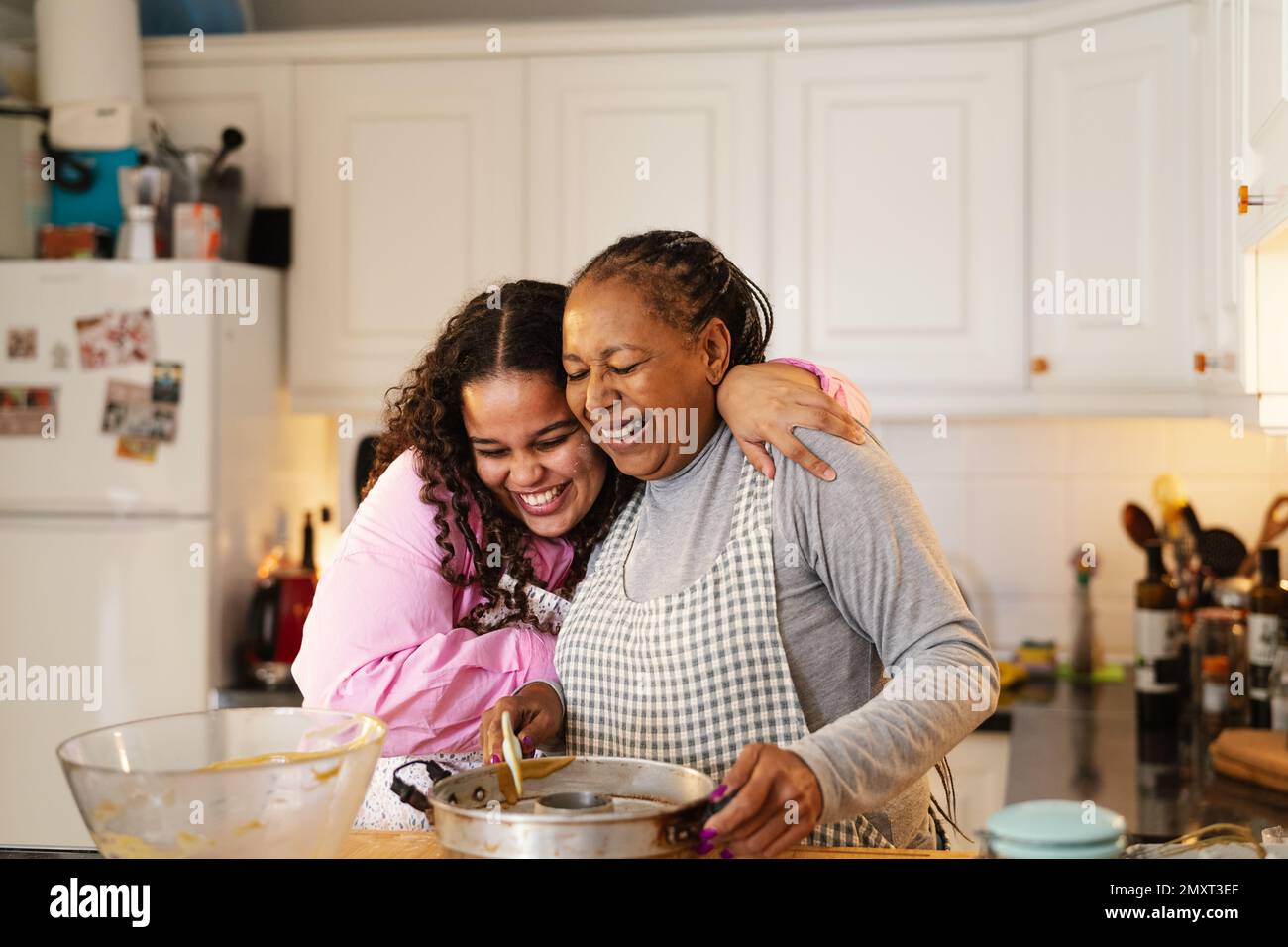 Happy African mother and daughter preparing a homemade dessert Stock ...
