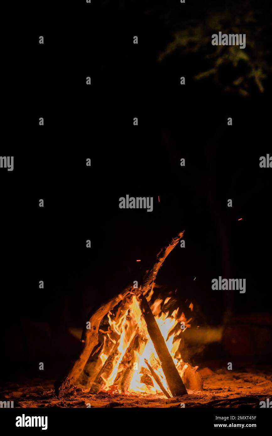 A big bonfire surrounded by pitch darkness with empty space for text ...