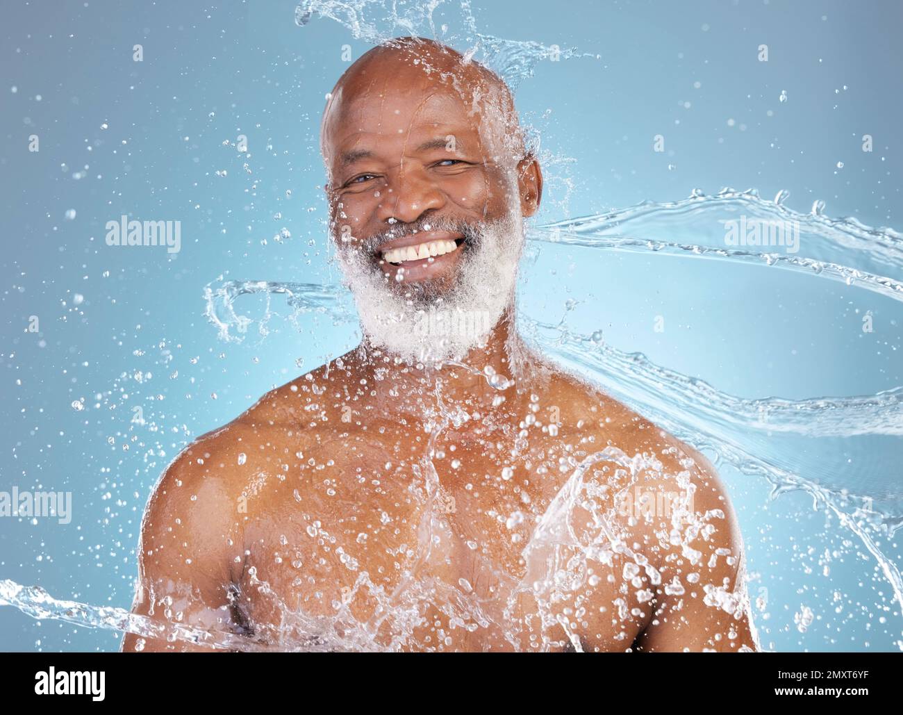Water splash, portrait and happy man isolated on blue background for ...