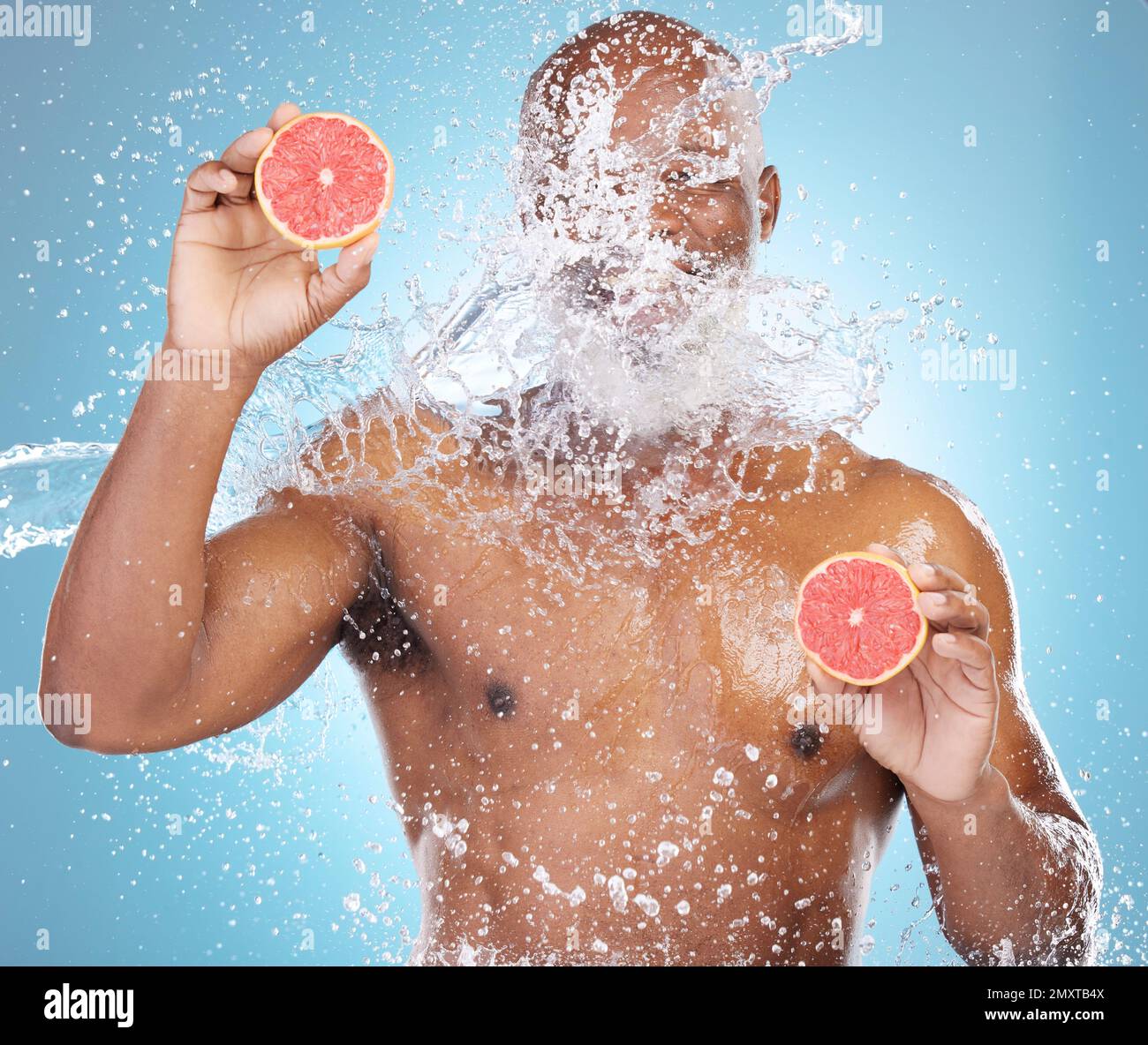 Black man, water splash and fruit for skincare, grapefruit or vitamin C and hydration against a ...