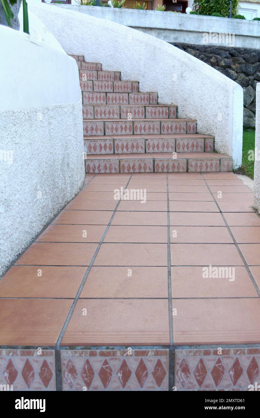 Exterior shot of a white painted wall with a narrow staircase with ...