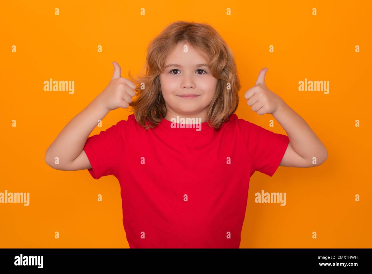Child showing thumbs up on studio isolated background. Kid boy making ...