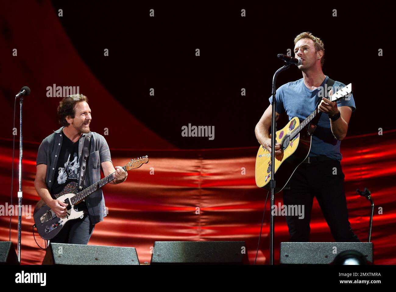Musicians Eddie Vedder, left, and Chris Martin perform together at the ...