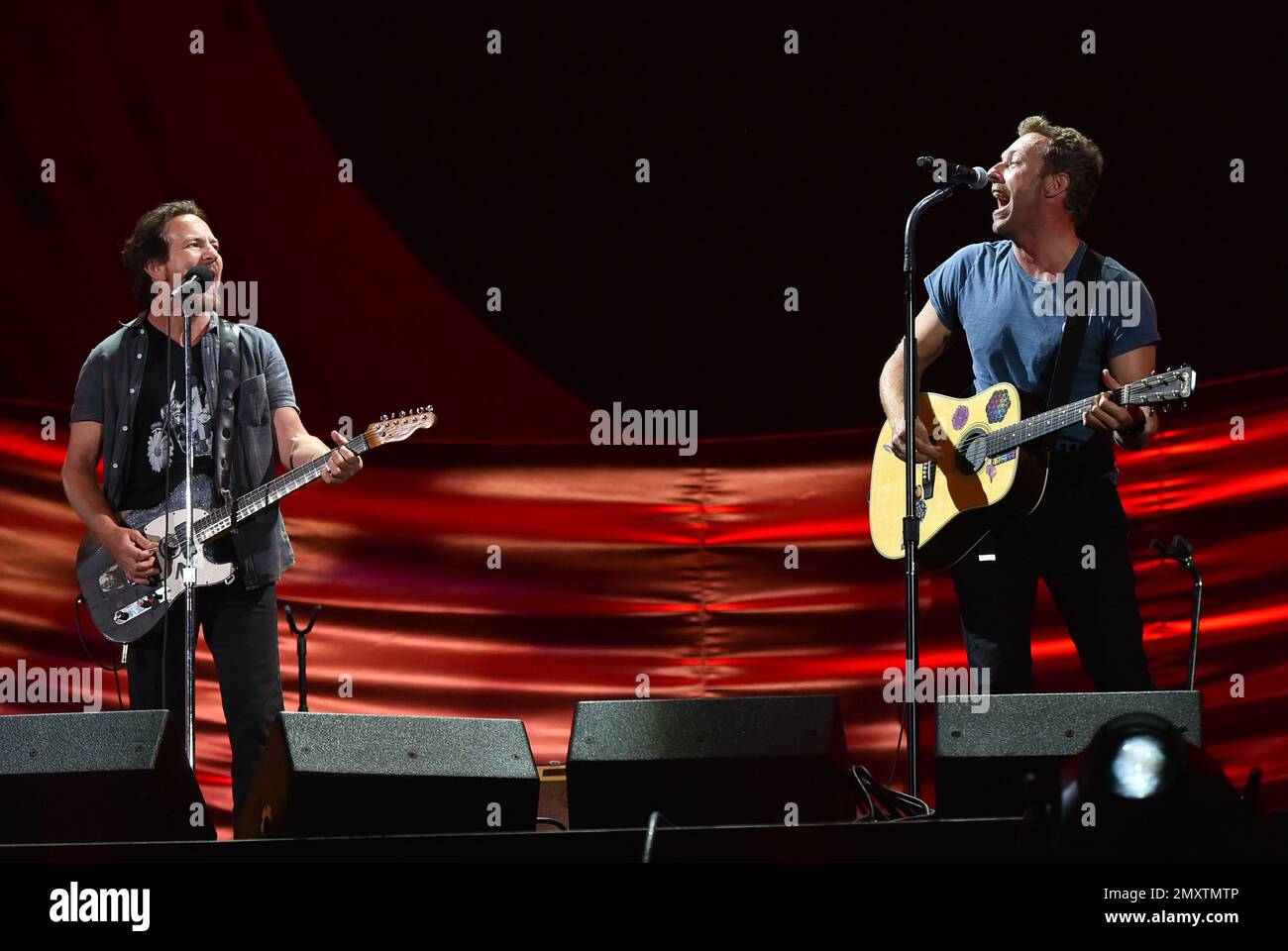 Musicians Eddie Vedder, left, and Chris Martin perform together at the ...