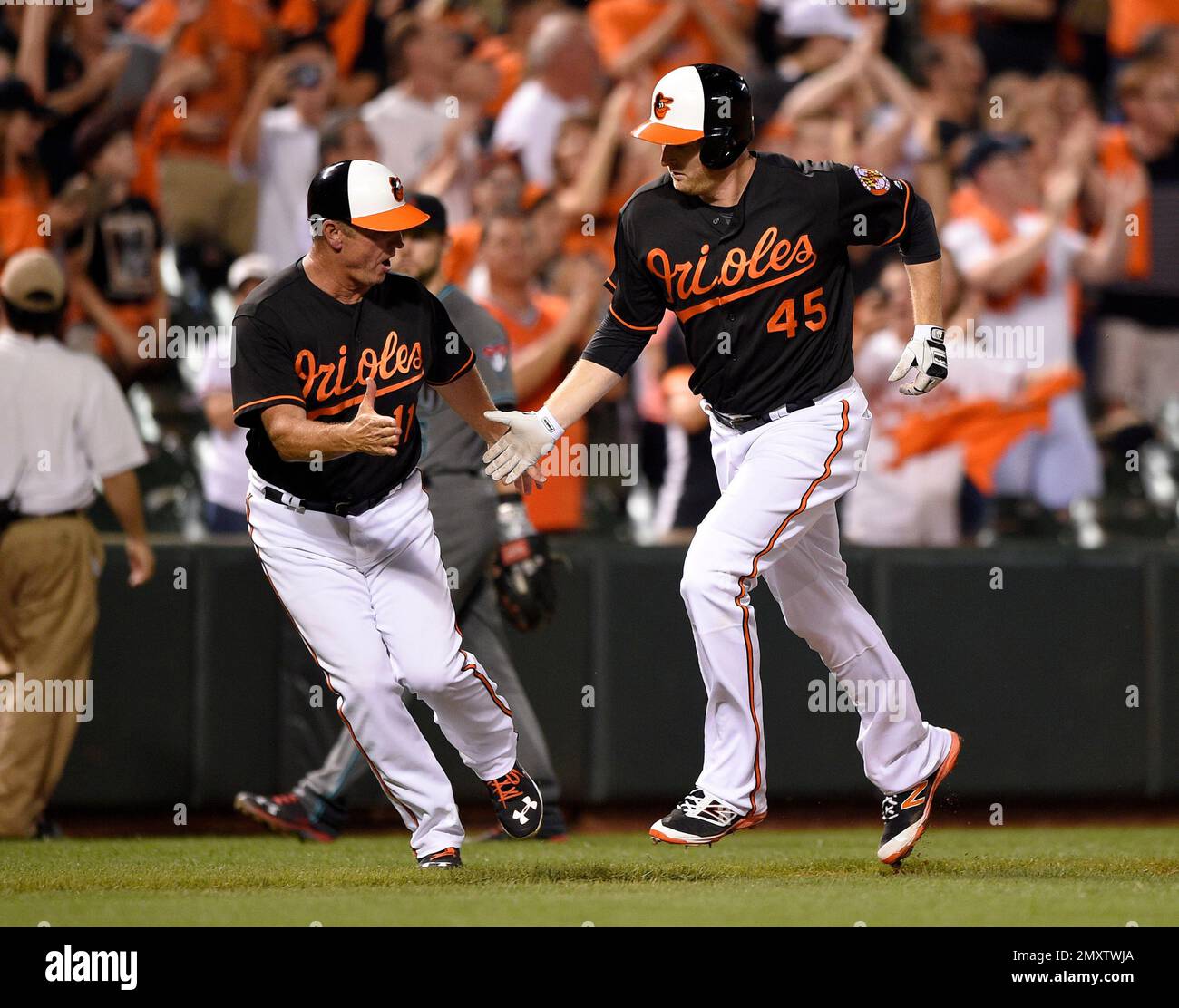 Baltimore Orioles' Mark Trumbo (45) is greeted by third base coach ...
