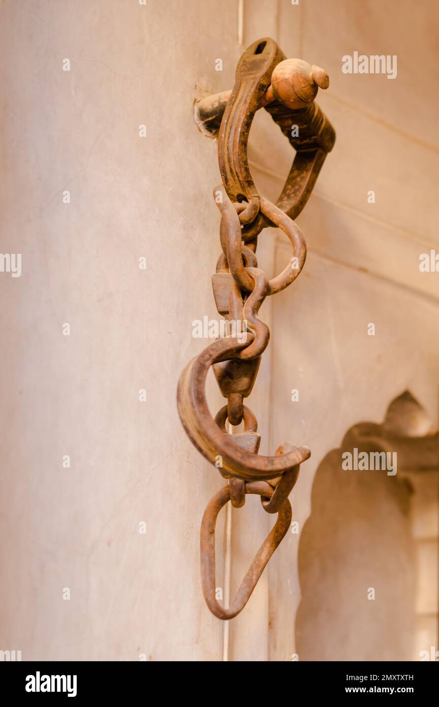 A vertical shot of vintage shackles for prisoners hang on the wall ...