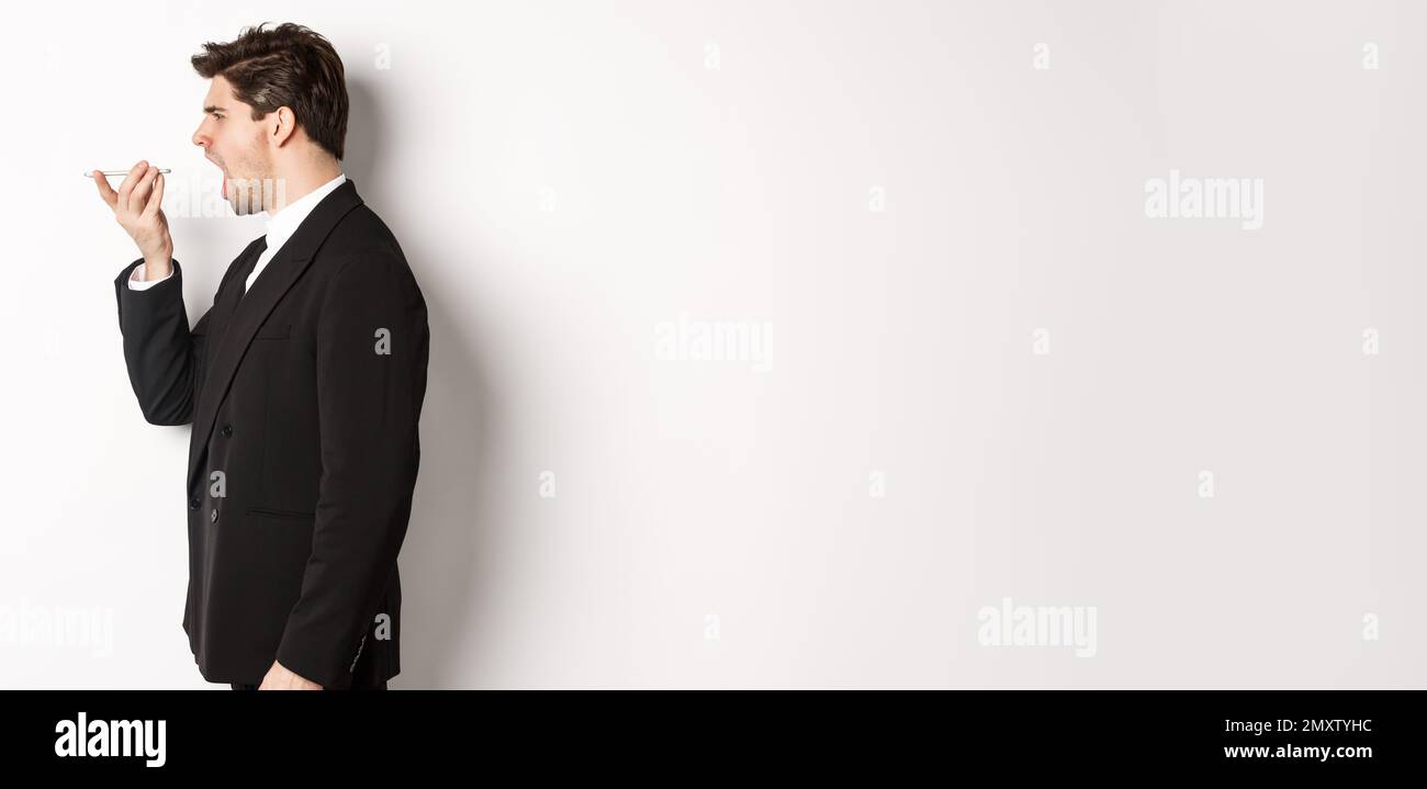 Profile shot of angry businessman in black suit, shouting at ...