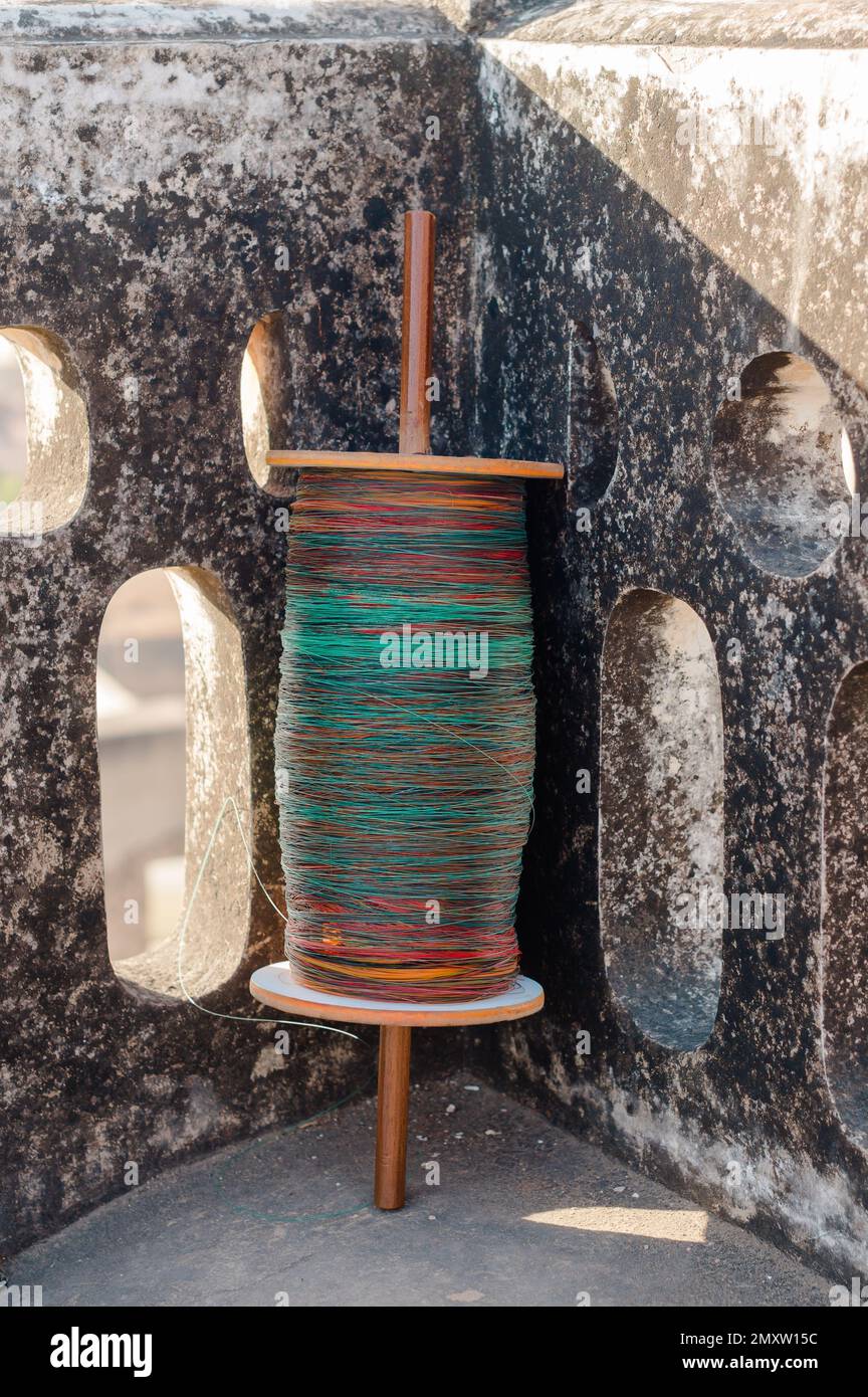 A vertical shot of a vintage thread rack leant on a structure with ...