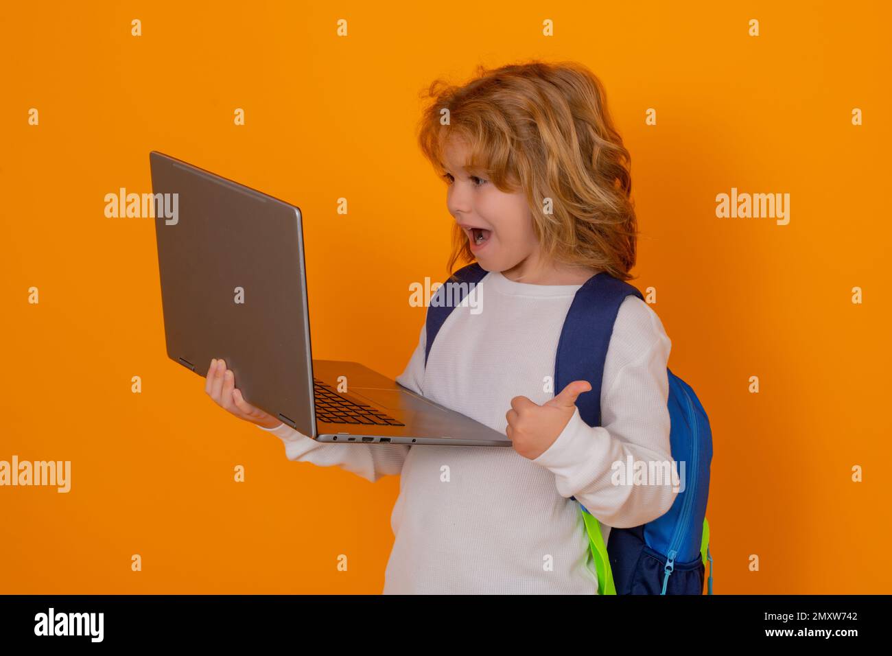 Isolated portrait of school child. School child using laptop computer ...