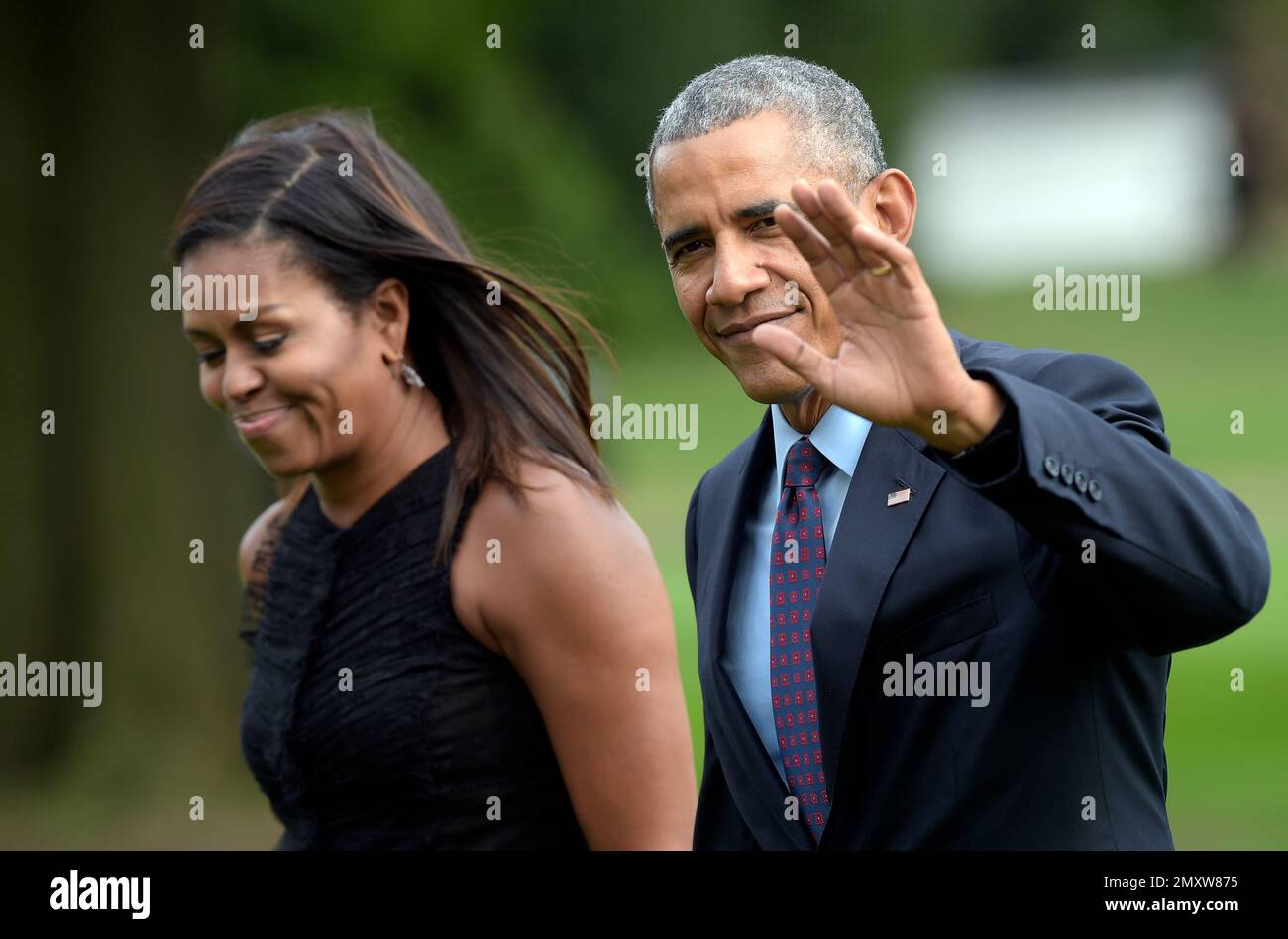 President Barack Obama, with first lady Michelle Obama, waves as they ...