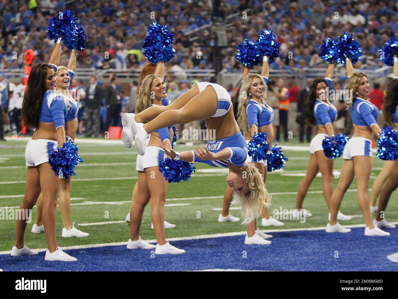 A Detroit Lions cheerleader performs a flip in front of the squad ...