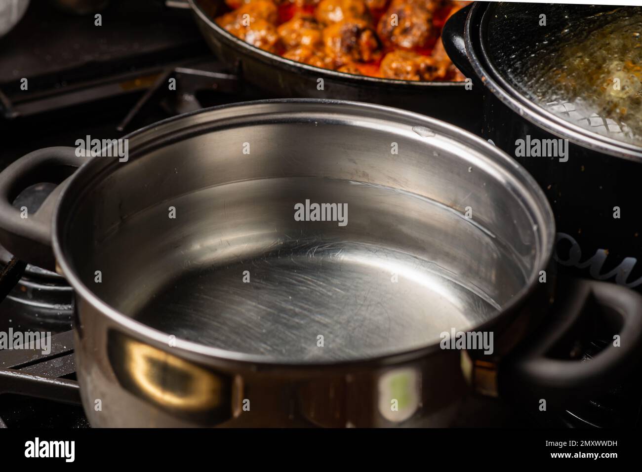 Water in a pot is on the stove in the kitchen. Preparation for boiling ...