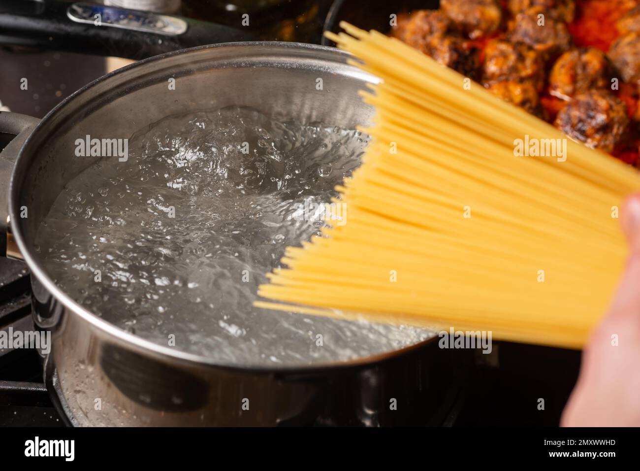 Dip spaghetti into boiling water in a saucepan. Pasta cooking Stock ...