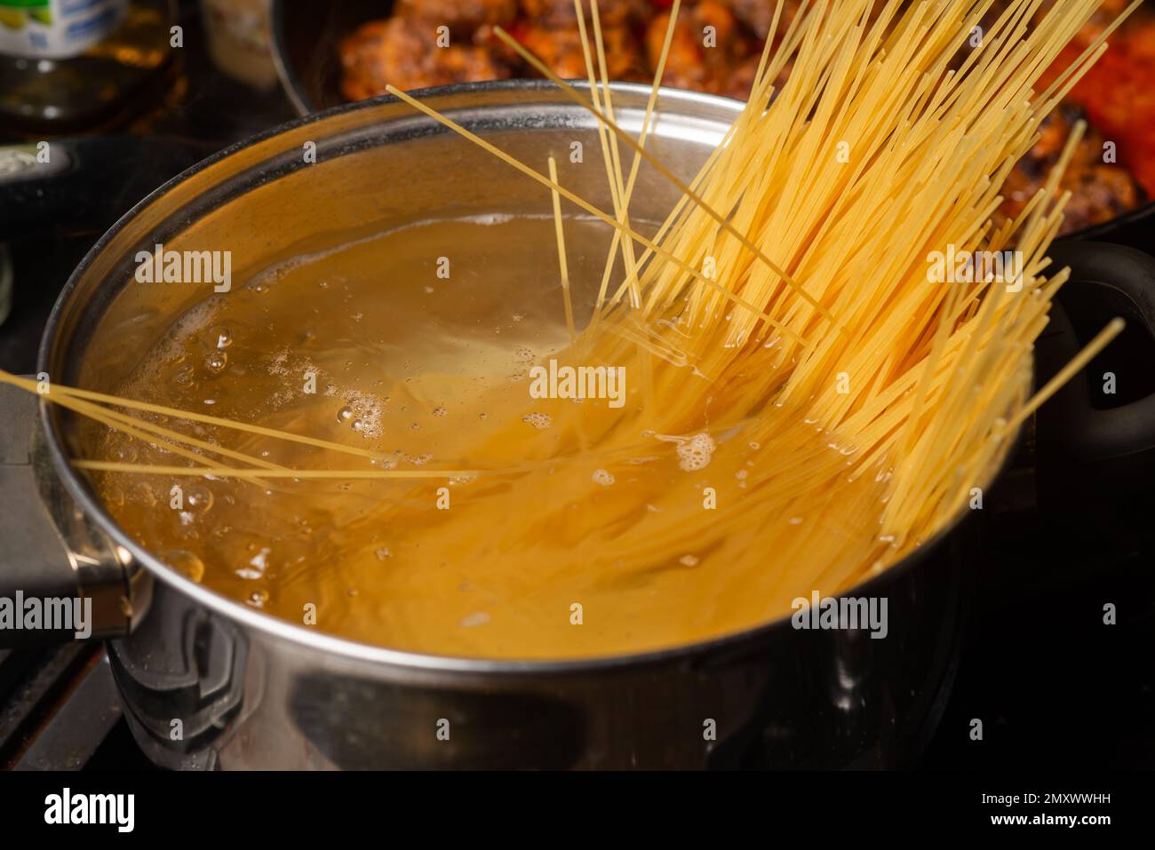 Dip spaghetti into boiling water in a saucepan. Pasta cooking Stock ...