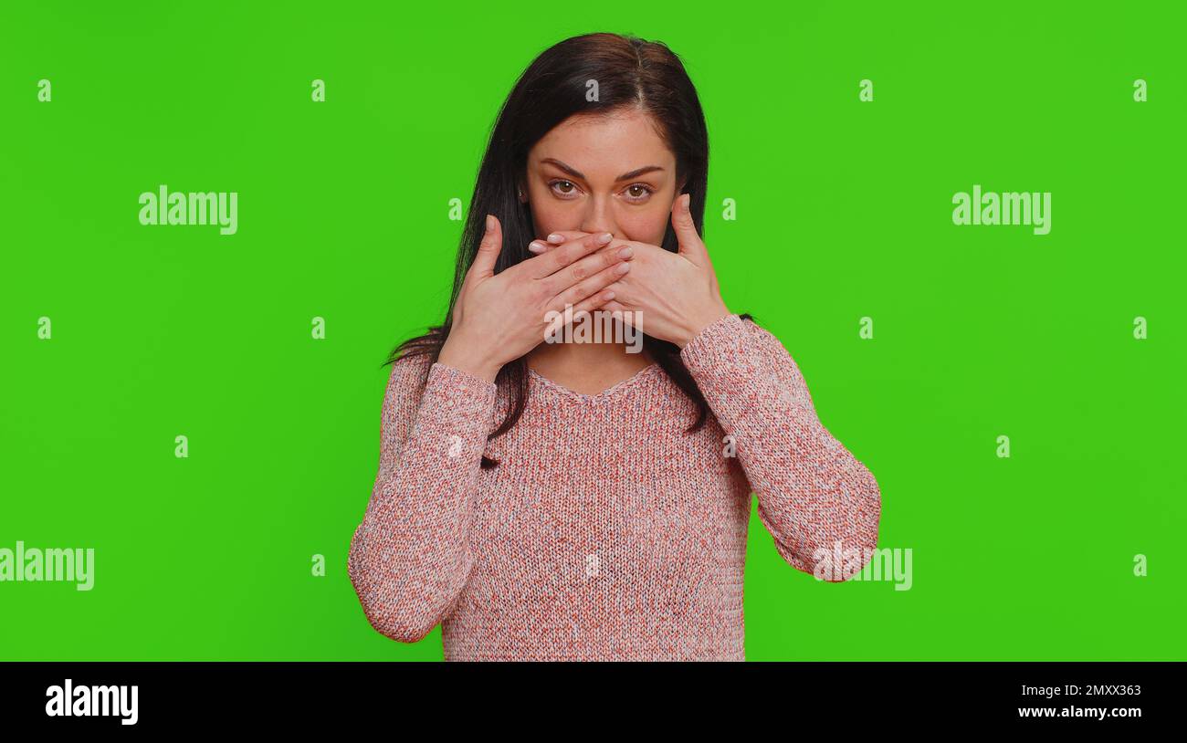 I will not say anyone. Frightened woman closing mouth with hands ...