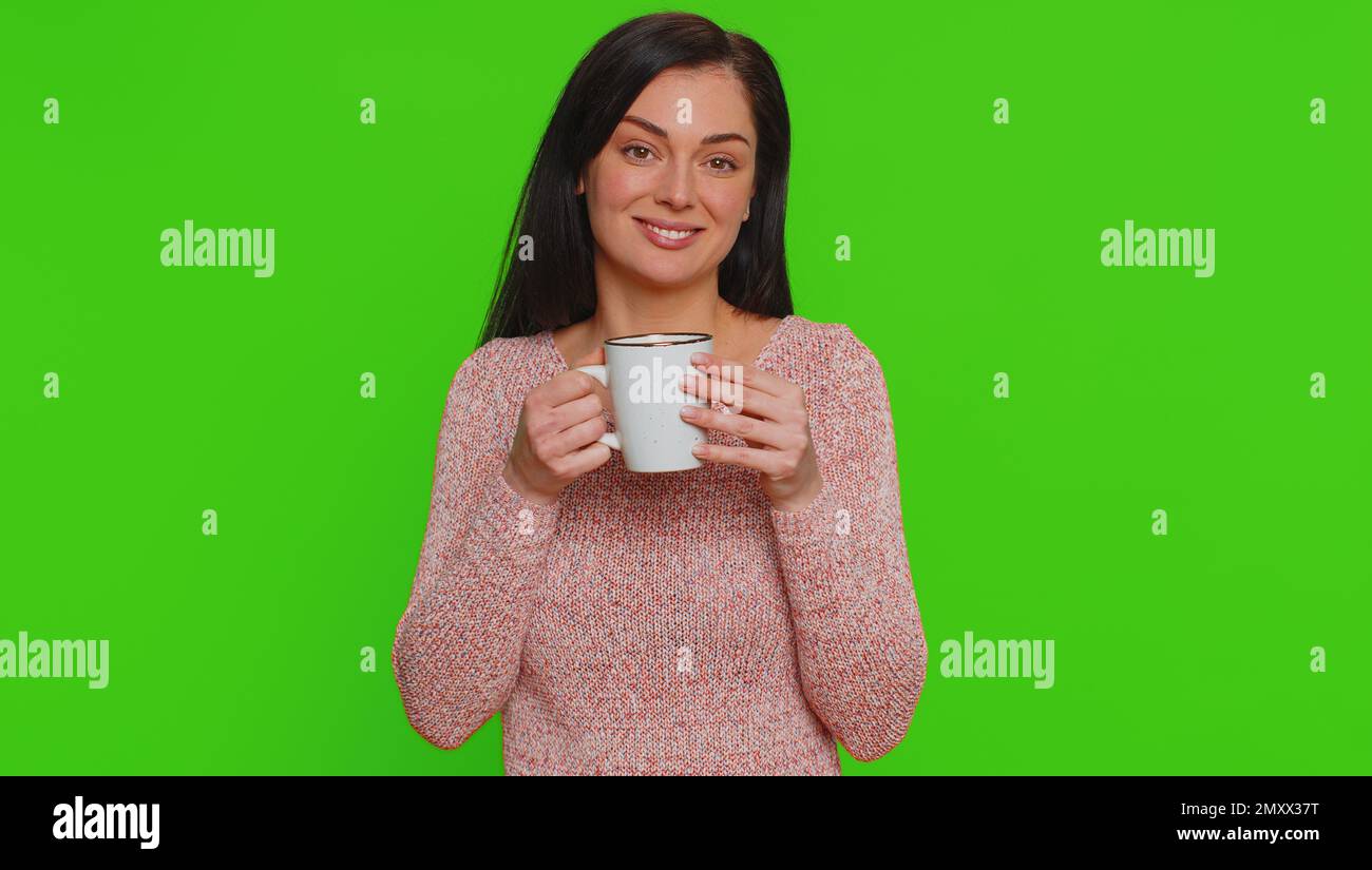 Pretty young woman smelling drinking cup of beverage hot coffee, taking ...
