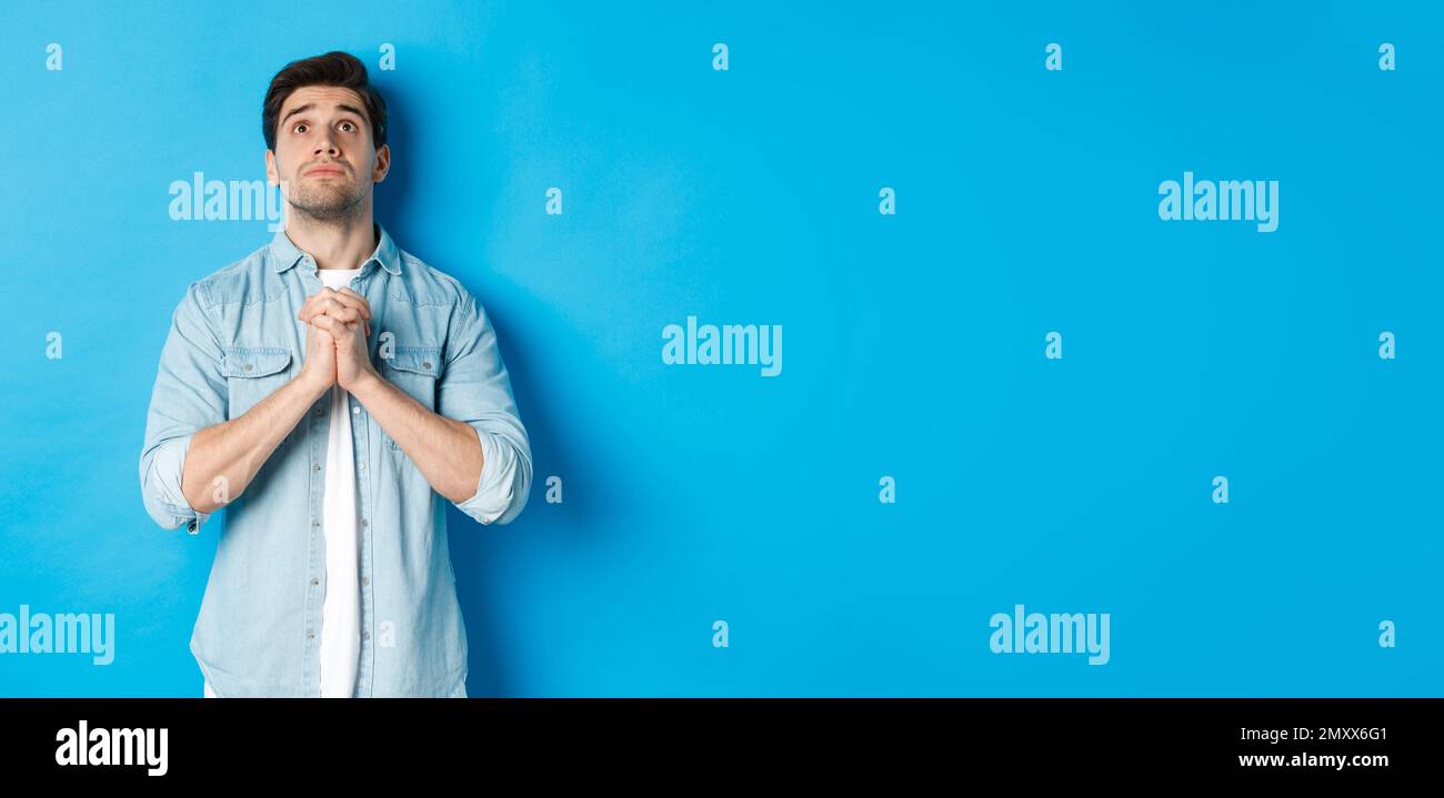 Hopeful young man looking up and praying God, begging for help ...