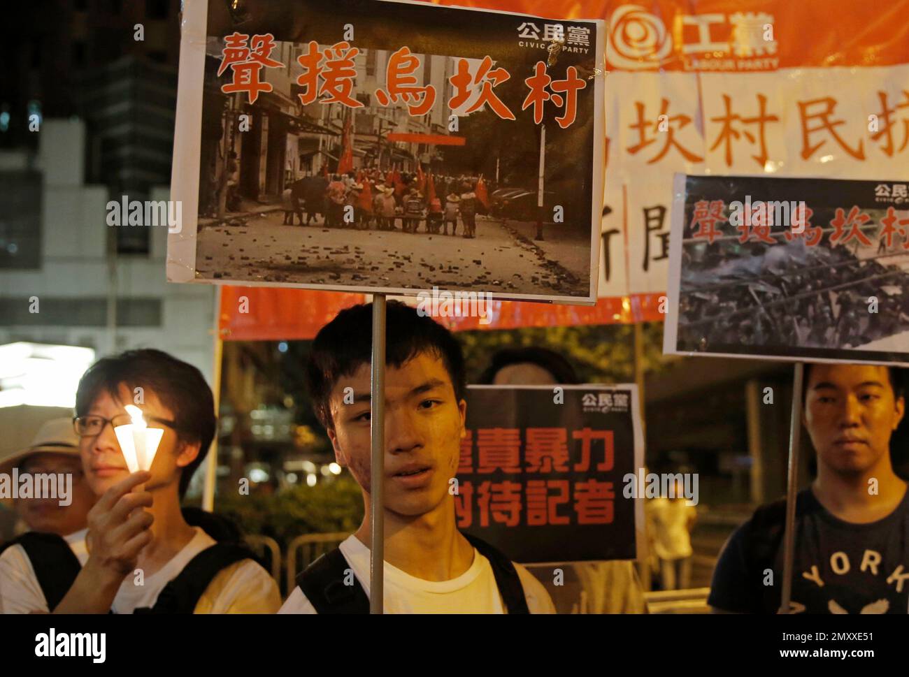 Protesters hold pictures of Chinese armed riot police and Wukan ...