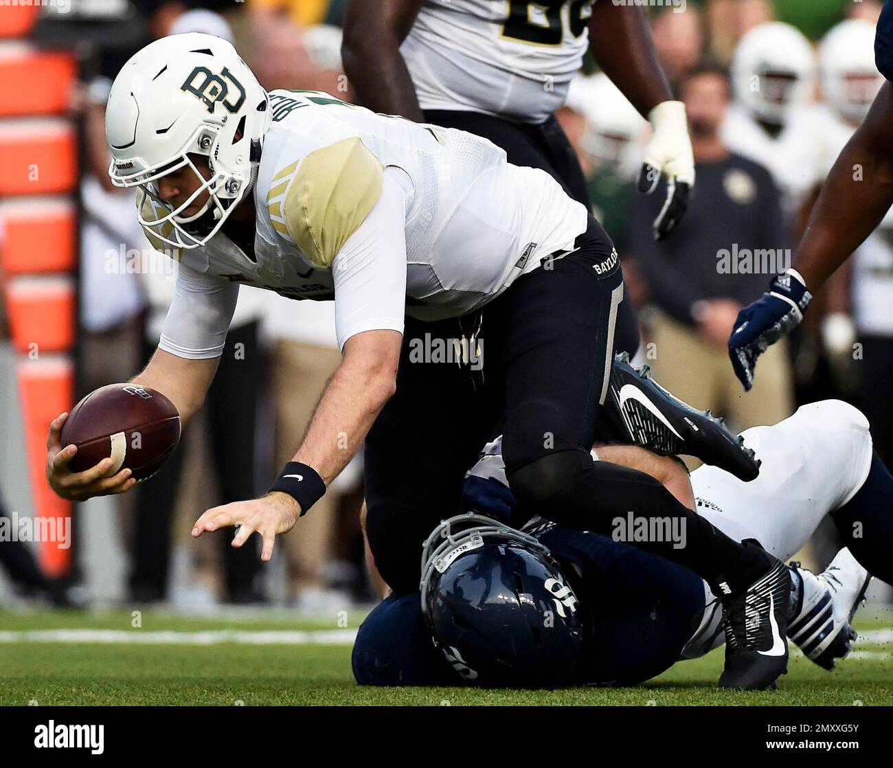 Baylor quarterback Seth Russell, left, is sacked by Rice defensive end ...