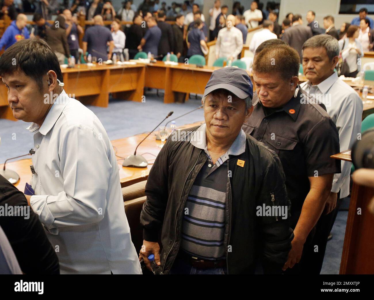 Former Filipino militiaman Edgar Matobato, center, walks under tight ...