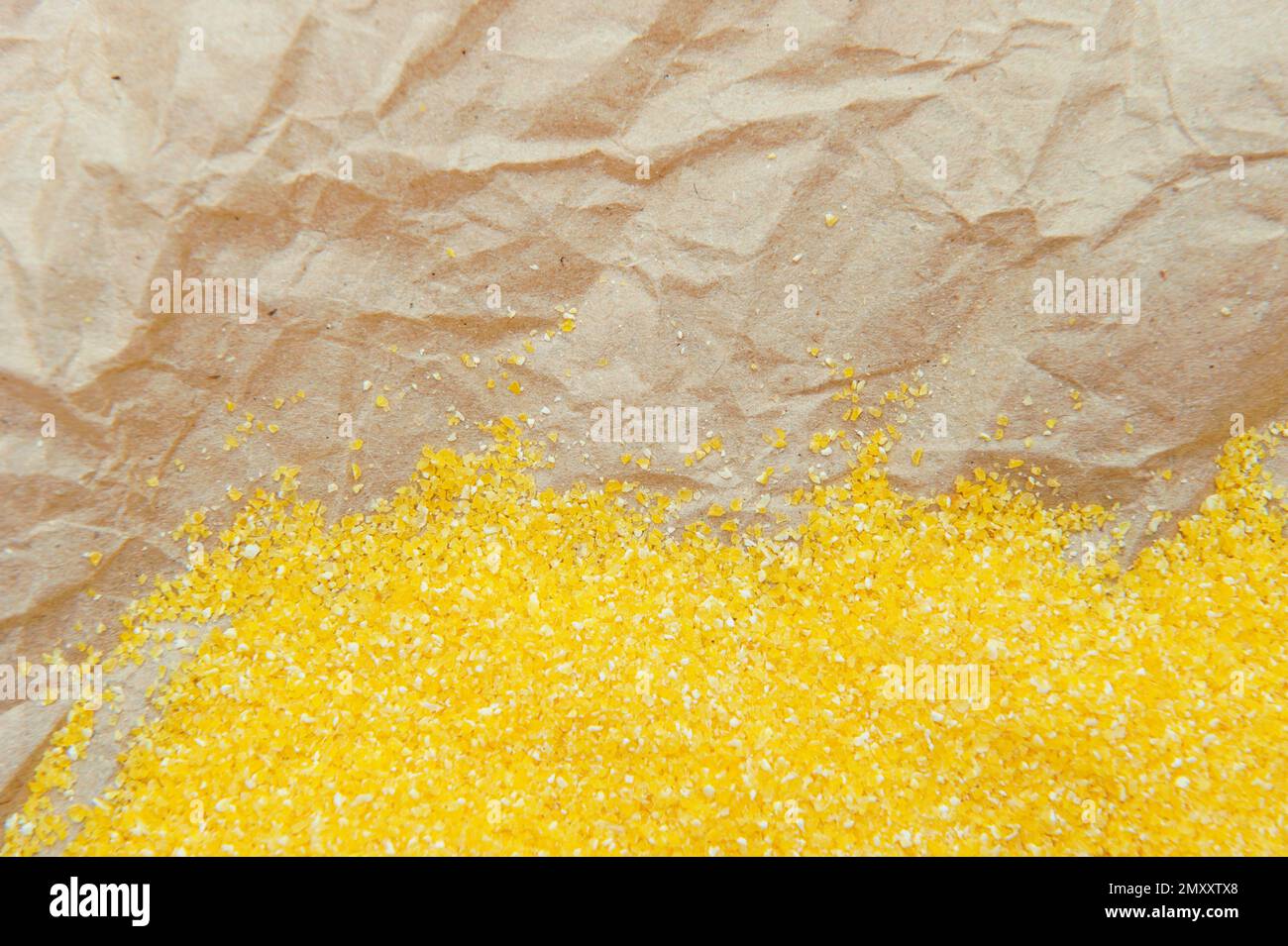 background with ground corn on crumpled old parchment wrapping paper ...