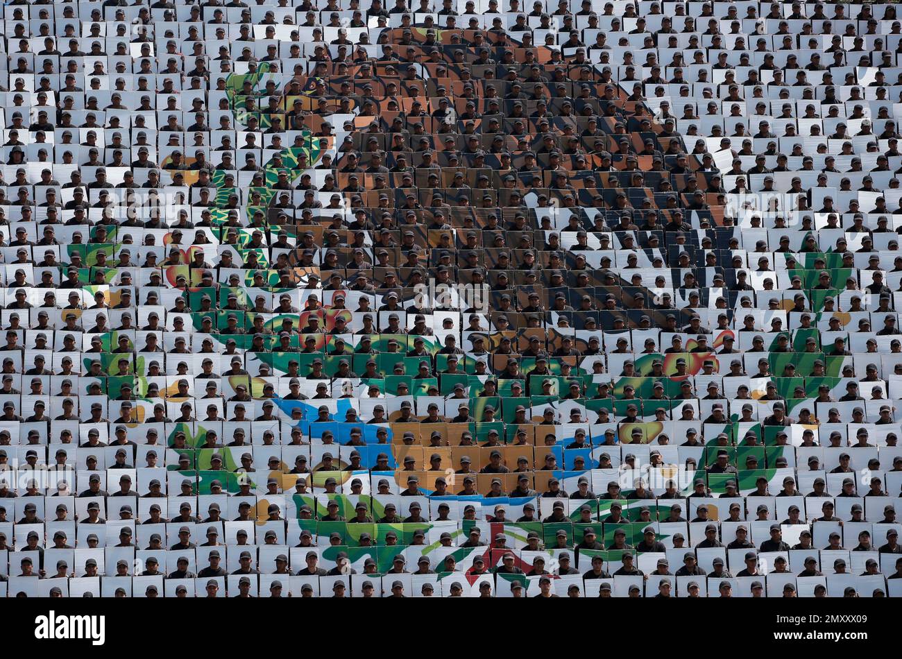 Hundreds of military troops hold cards making a mosaic depiction of the ...