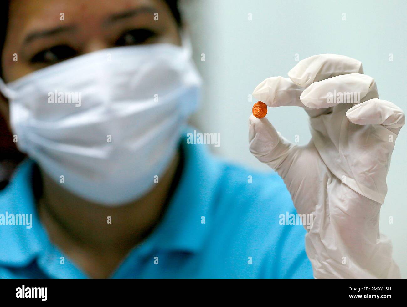 A Philippine Drug Enforcement agent shows a party drug pill known as ...