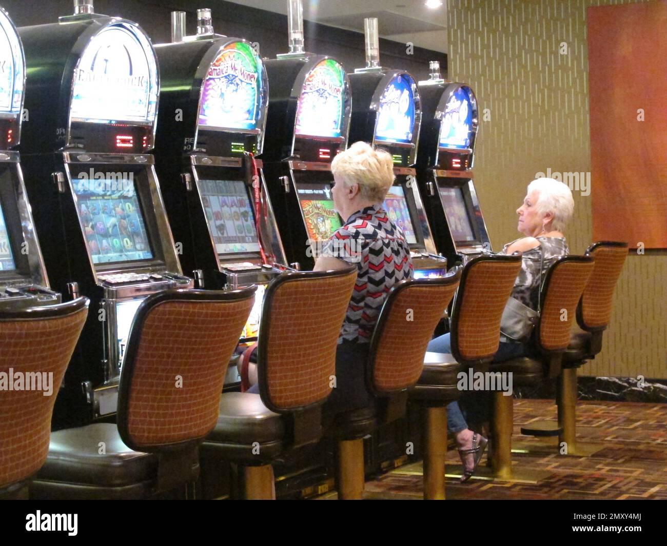 This June 24, 2016 photo shows gamblers playing slot machines at the ...