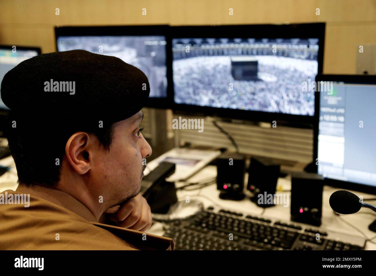 A Saudi security officer monitors live feed screens showing Muslim ...