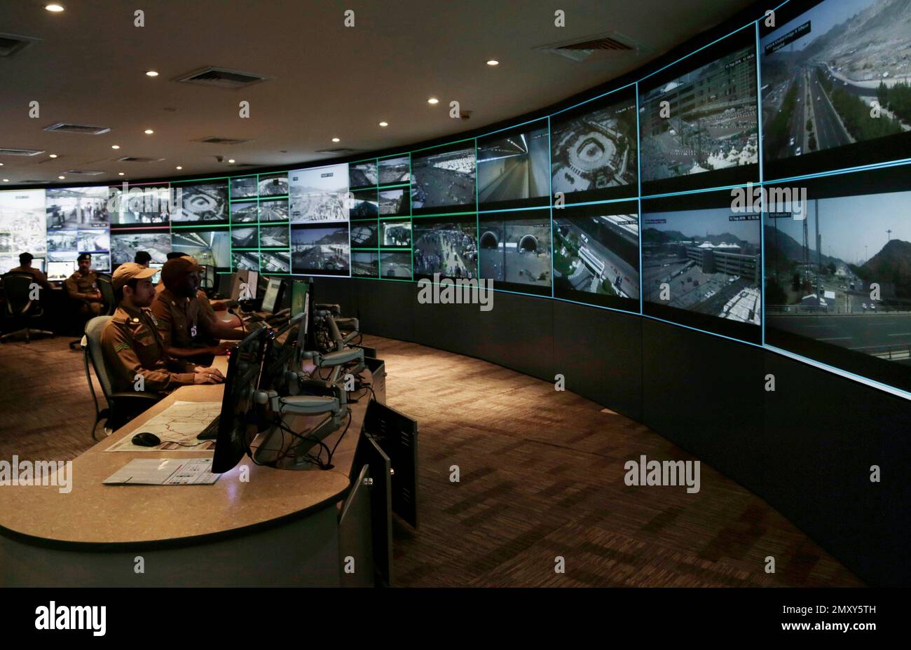 Saudi security officers monitor live feed screens showing Muslim ...