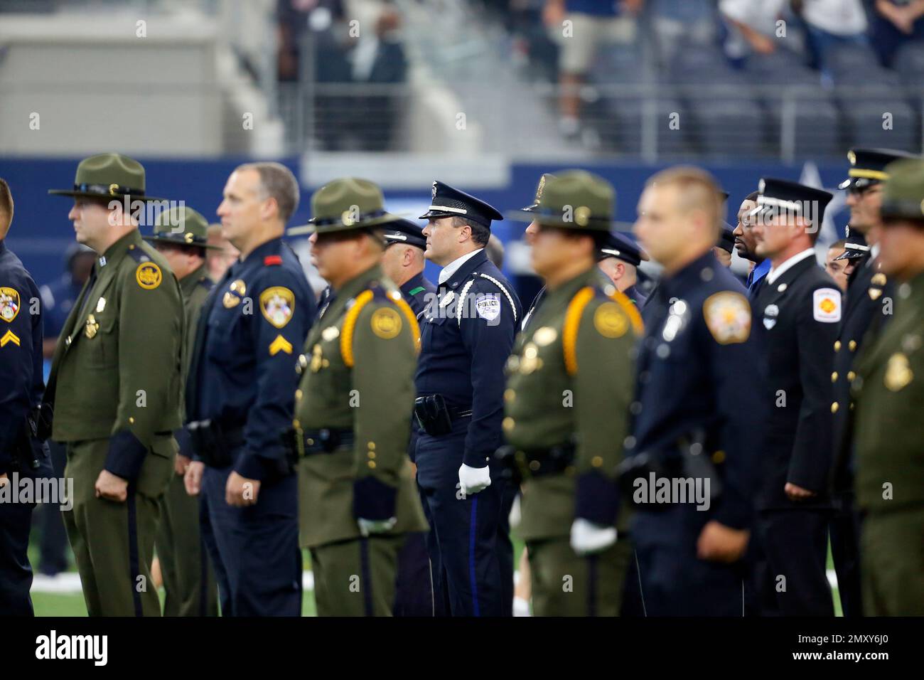 First responders stand at attention on the field during a law ...