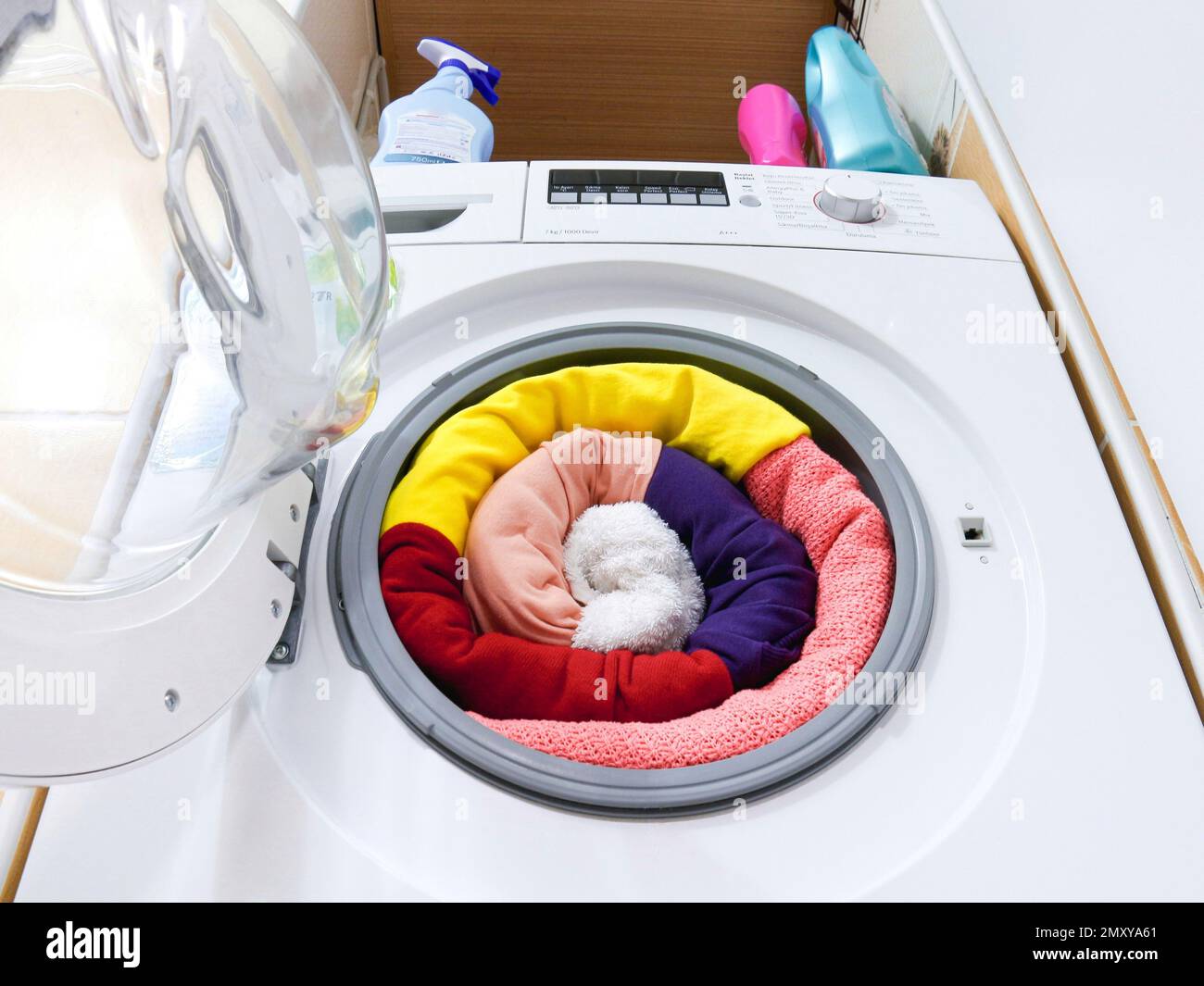 colored and a white laundry spiral shape spinning in washing machine ...