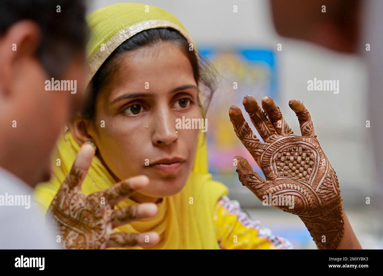 An Indian Muslim woman gets henna designs applied on their hand on the ...