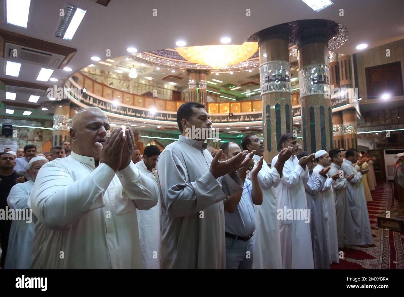 Iraqi Shia Muslims attend prayers on the first day of Eid al-Adha at ...