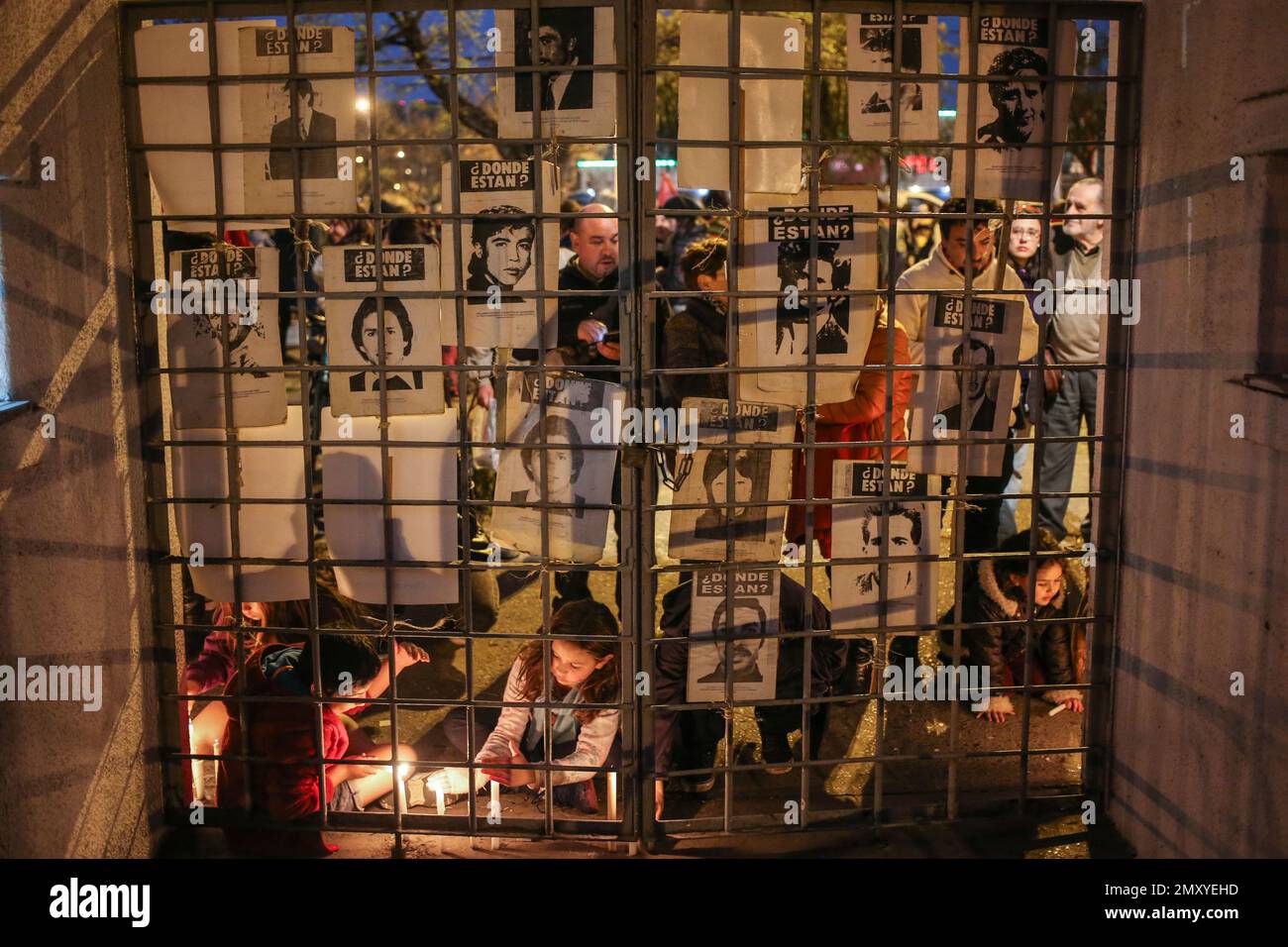 A woman lights a candle at the National Stadium, that served as a ...